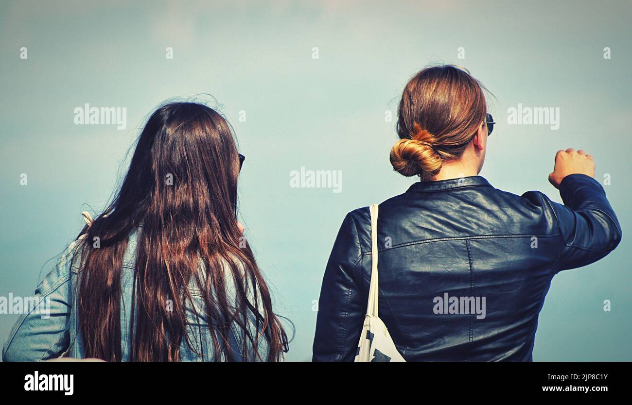 A backside view of two women looking at the horizon Stock Photo - Alamy