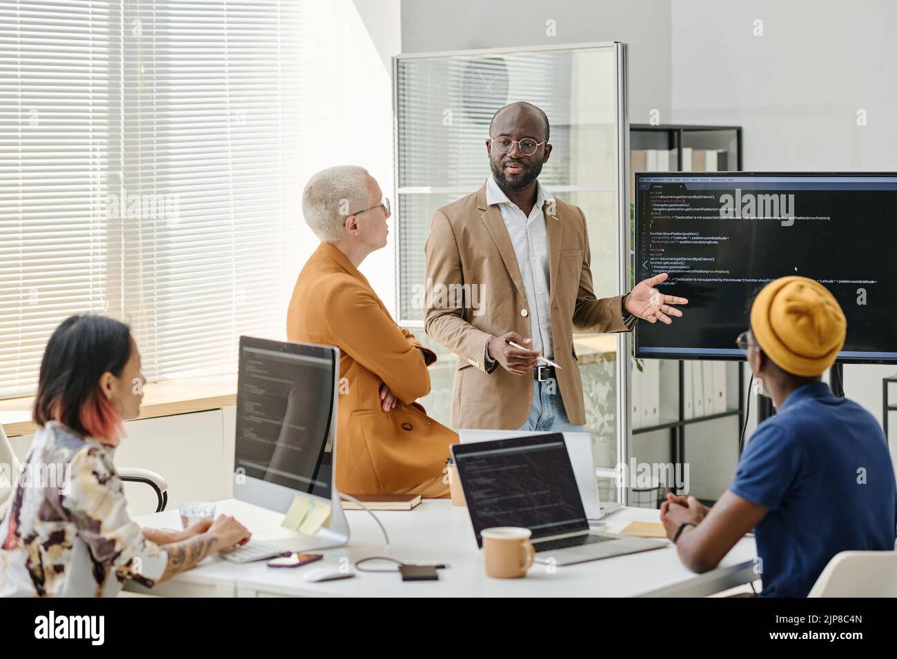 African businessman standing near the screen with presentation and ...