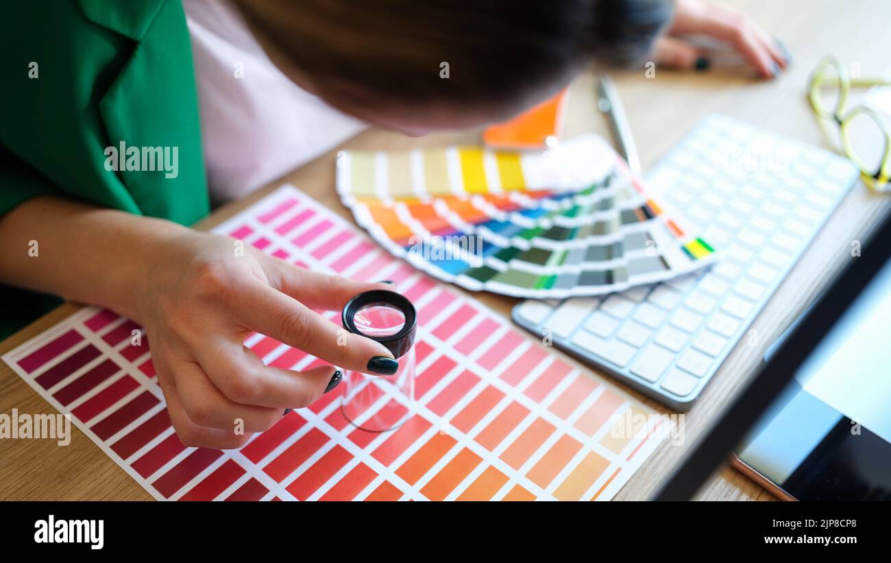Female searching proper colour for promotion and looking though loupe ...