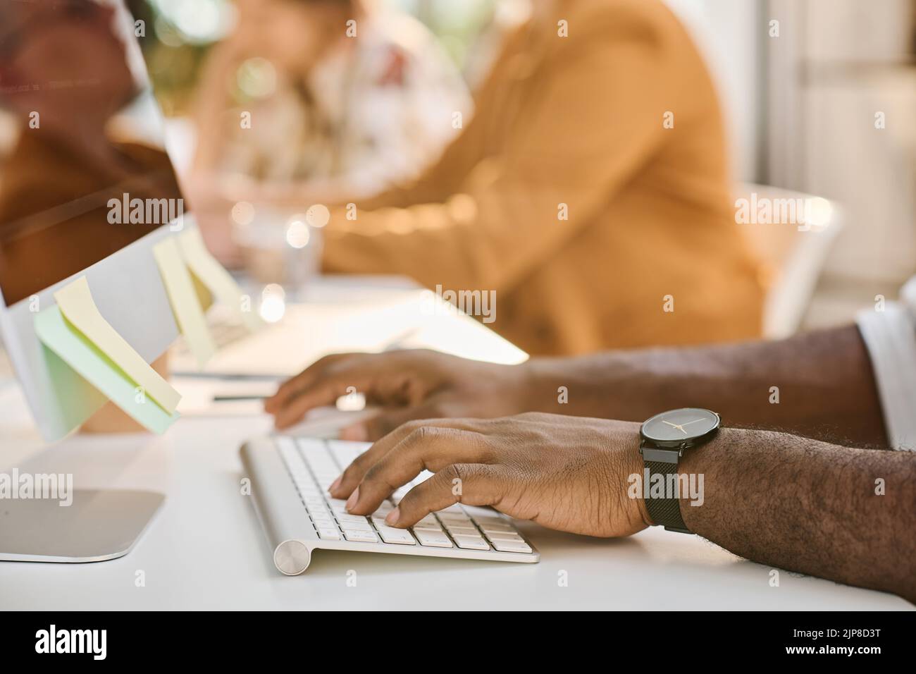 Close-up of African programmer typing on keyboard at his workplace at ...