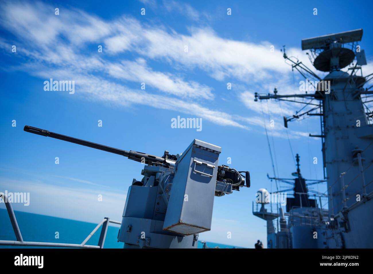Color image of an automated machine gun on the deck of a military ship ...