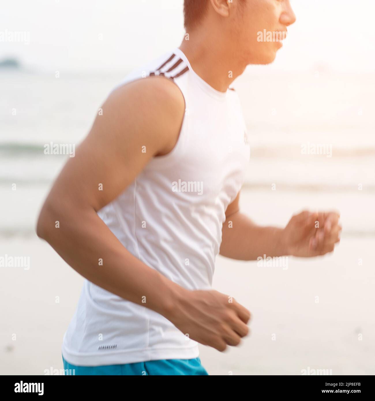 asian sport man running along seaside. running on beach with healthy ...