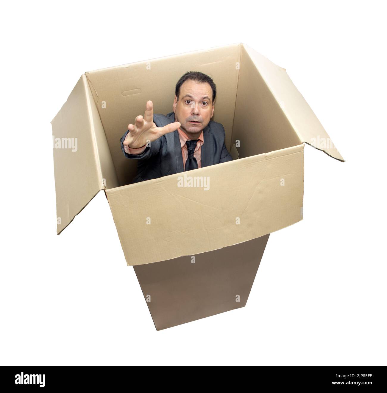 A man in a suit stands inside a cardboard box with his hand raised for ...