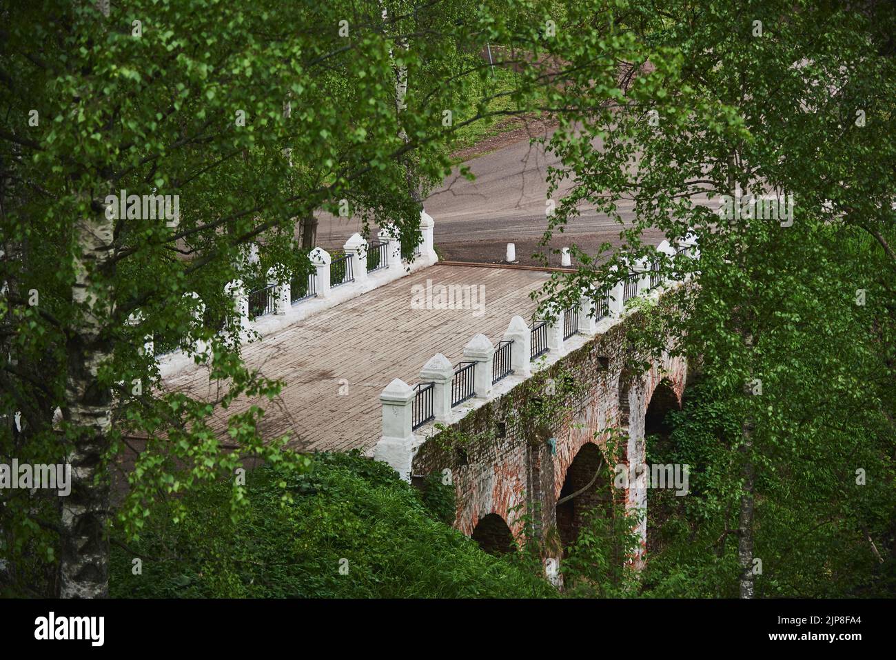 An old bridge with white pillars among green trees Stock Photo - Alamy