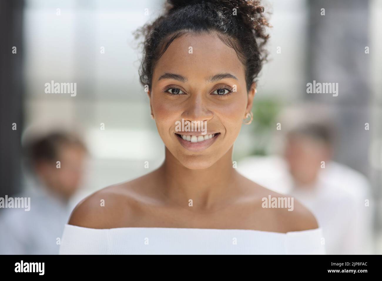 a business woman smiling inside office building Stock Photo - Alamy