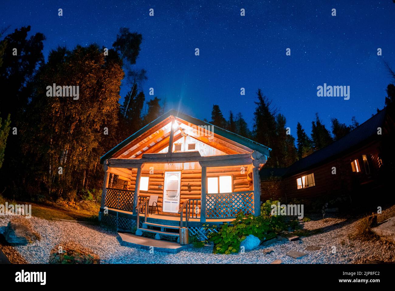 wooden cottage in the woods with starry milky way at night in the sky ...