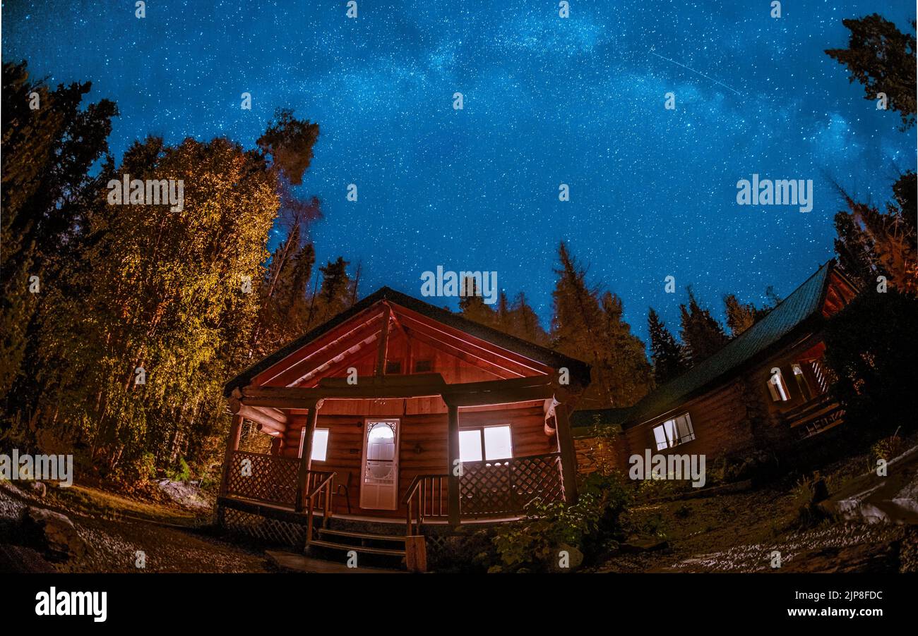 wooden cottage in the woods with starry milky way at night in the sky ...