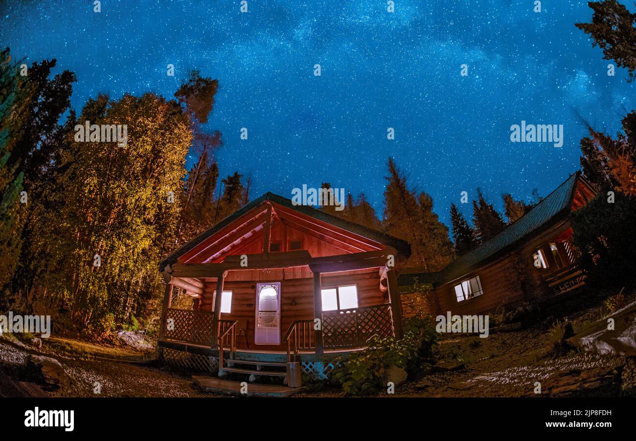 wooden cottage in the woods with starry milky way at night in the sky ...