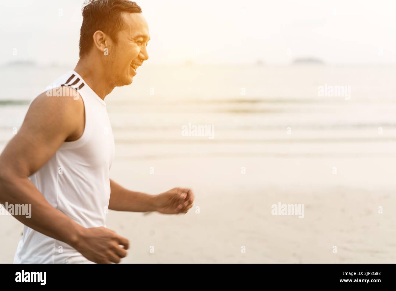 asian sport man running along seaside. running on beach with healthy ...