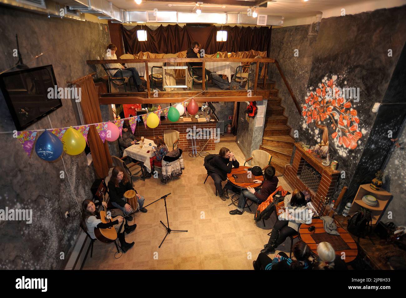 Interior of a small art cafe Tarelka (Plate), musicians on stage ready ...