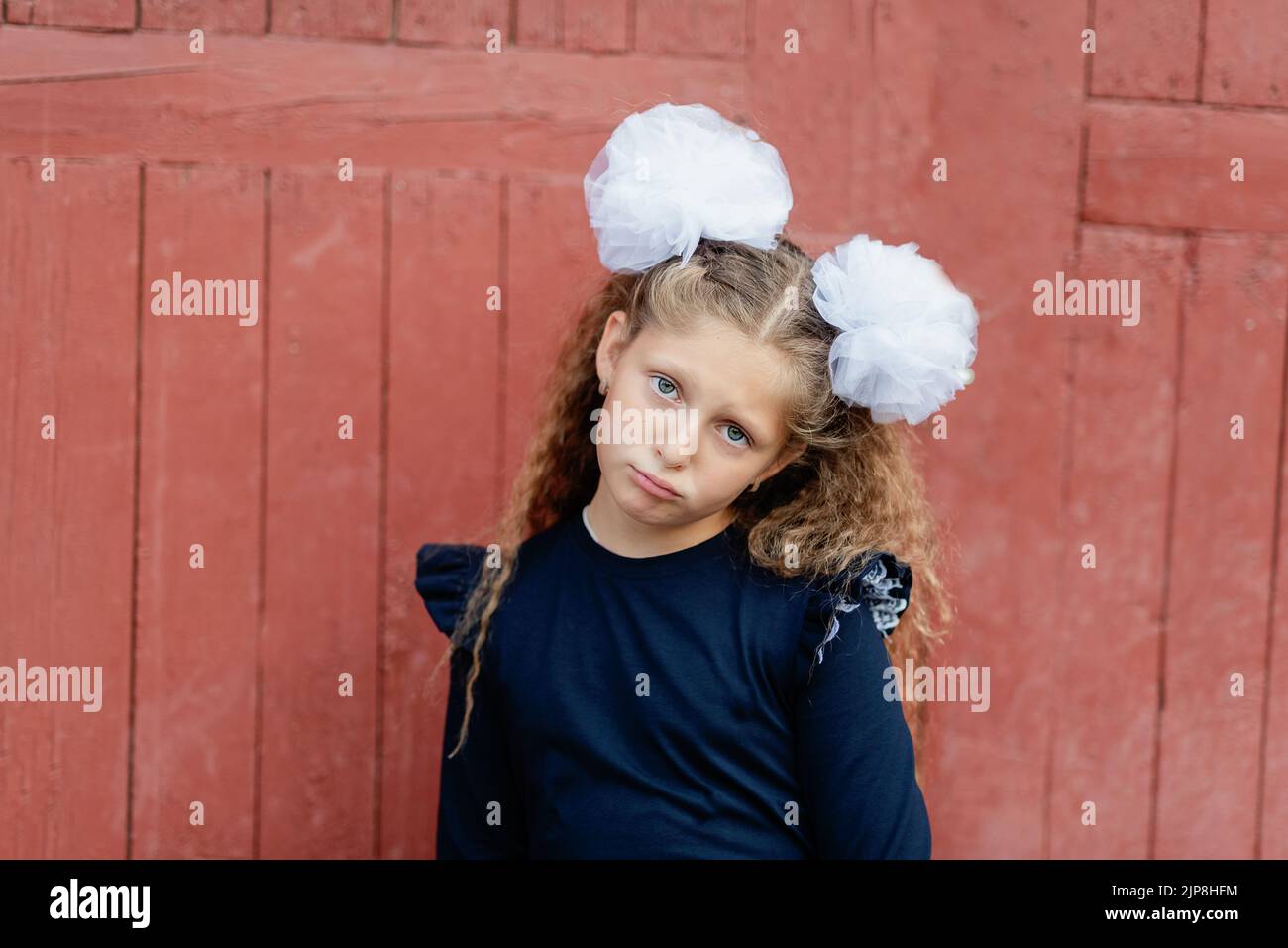 Portrait of a sad beautiful young schoolgirl is crying at the door of ...