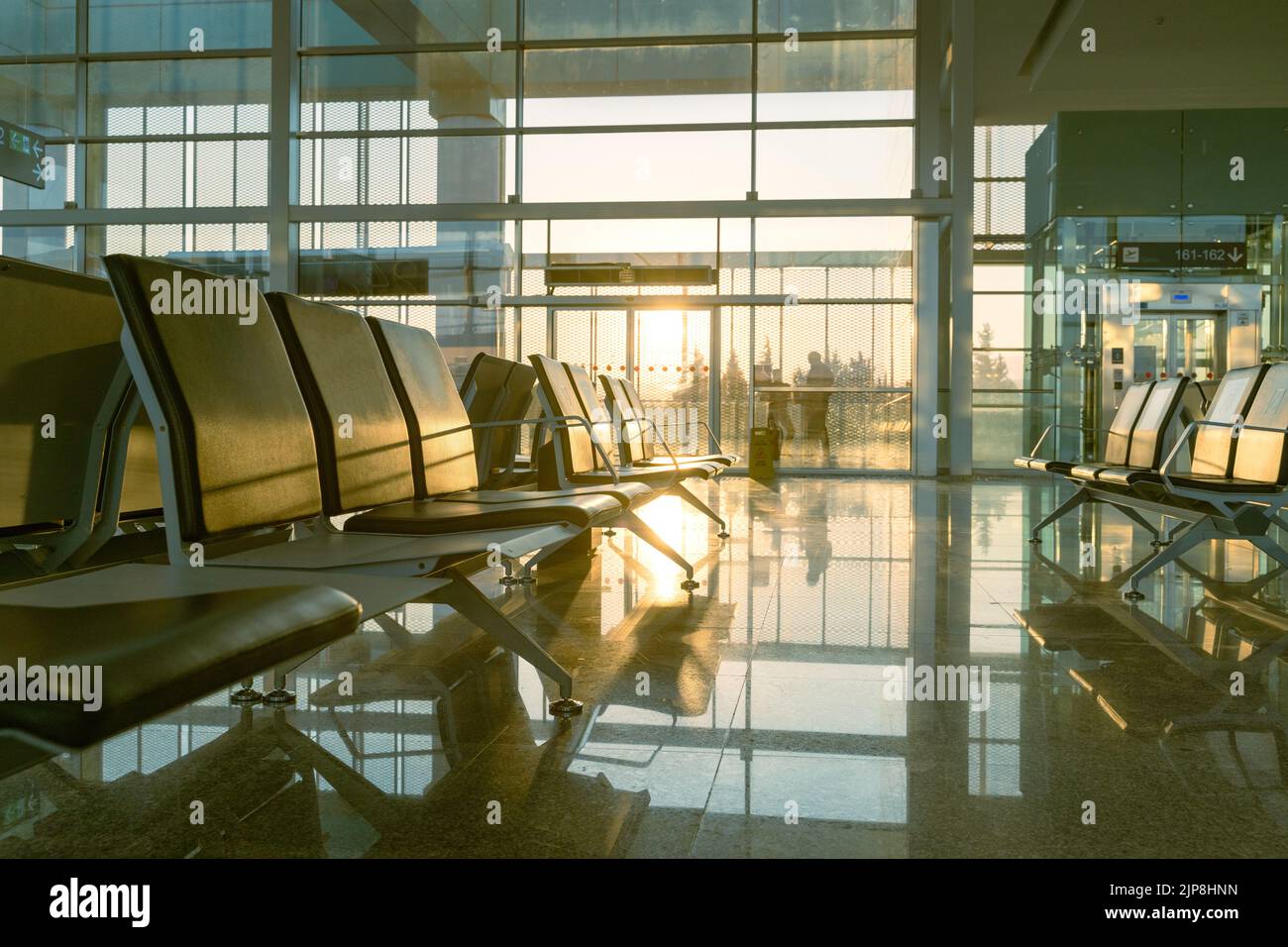 Interior of airport, passenger waiting area, empty terminal at sunset ...