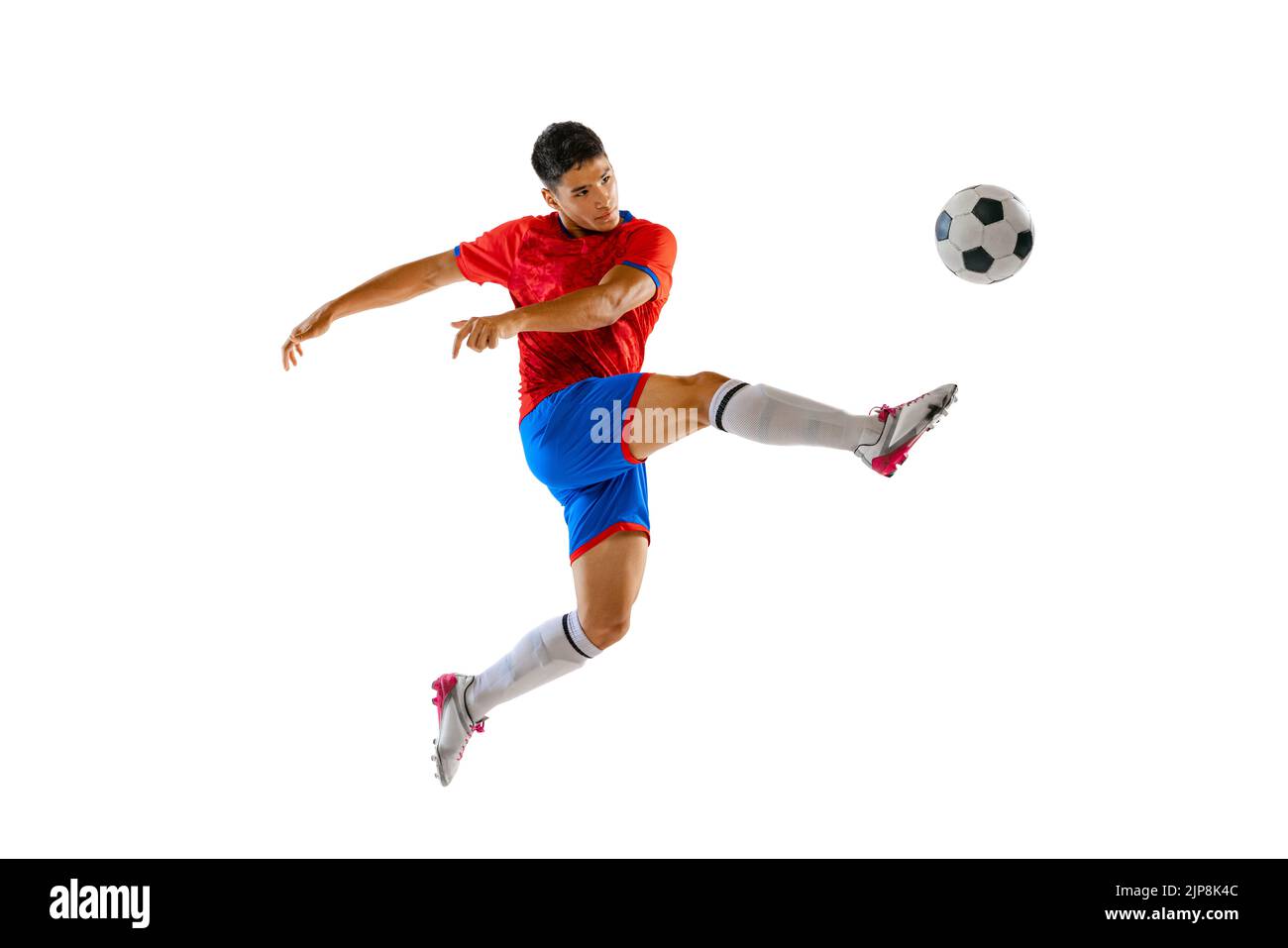Portrait of young man in uniform, professional football player kicking ...