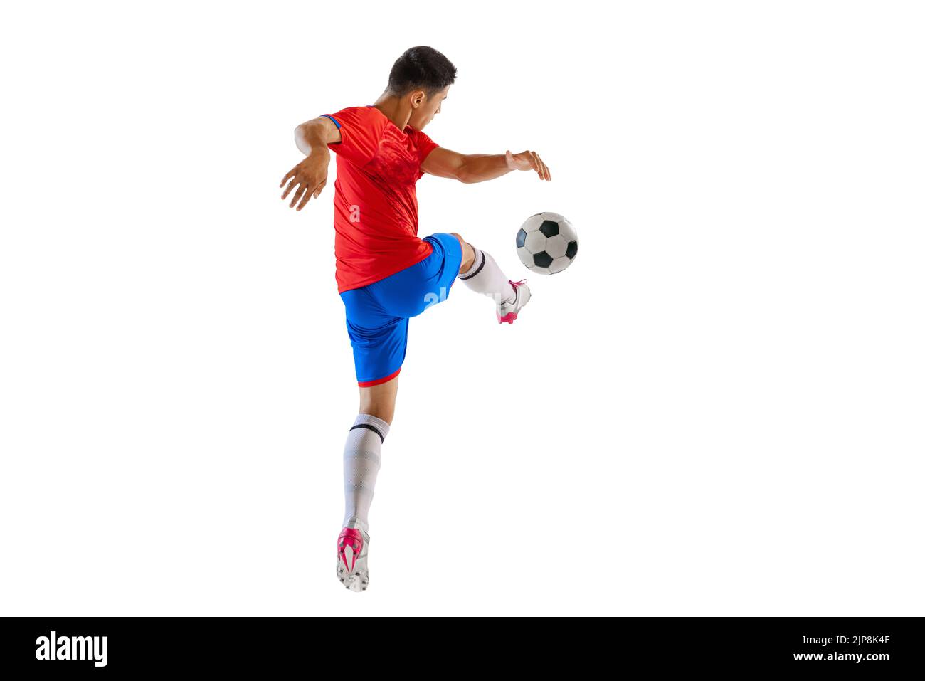 Dynamic portrait of young man, football player in motion, kicking ball ...