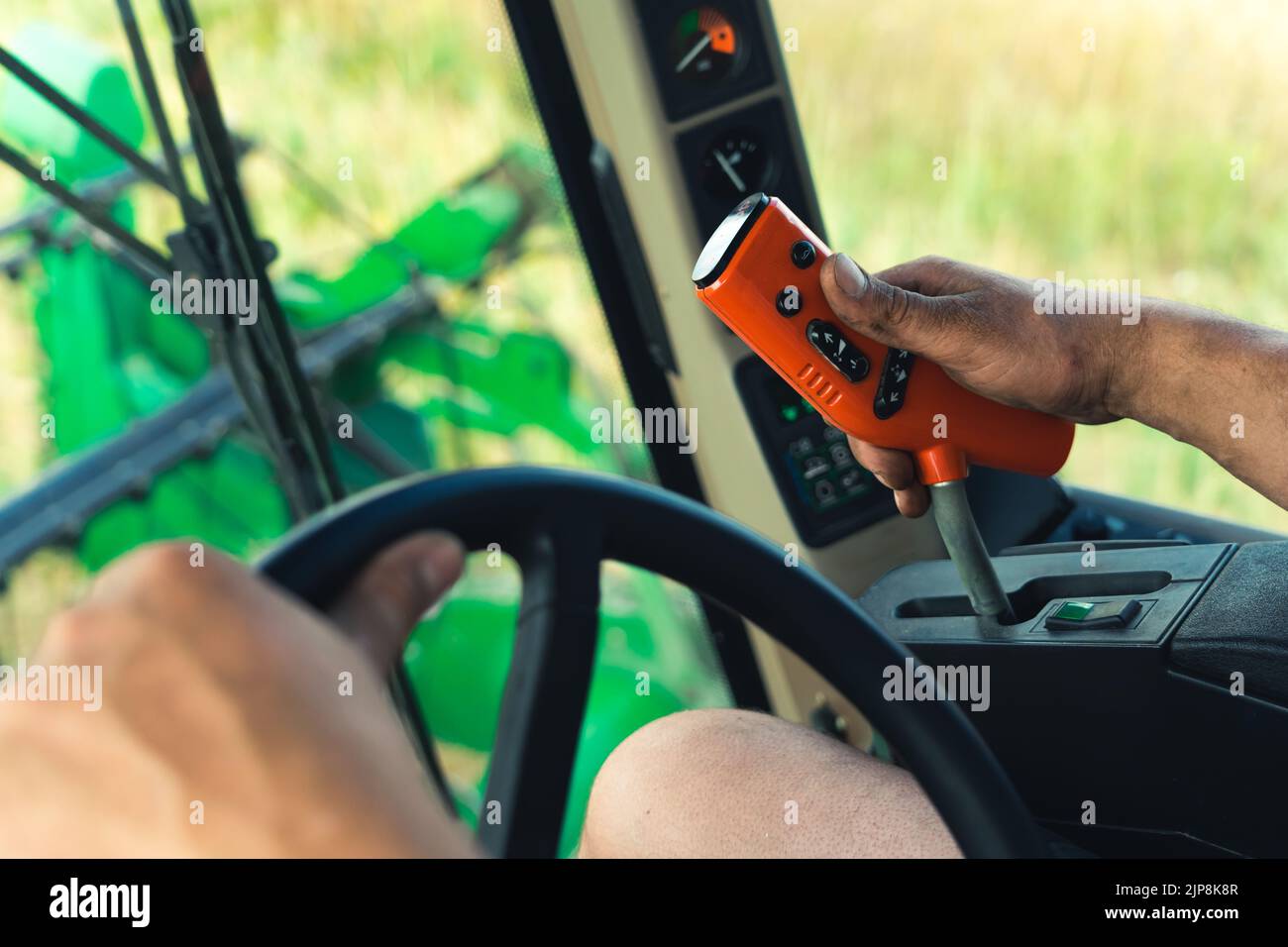 closeup view of farmer's hands driving combine harvester, tractor ...