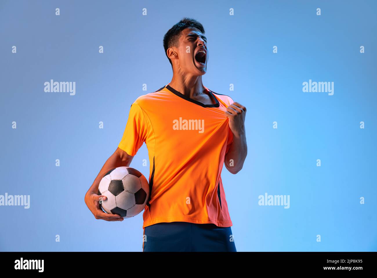 Portrait of young expressive man, football player posing isolated over ...