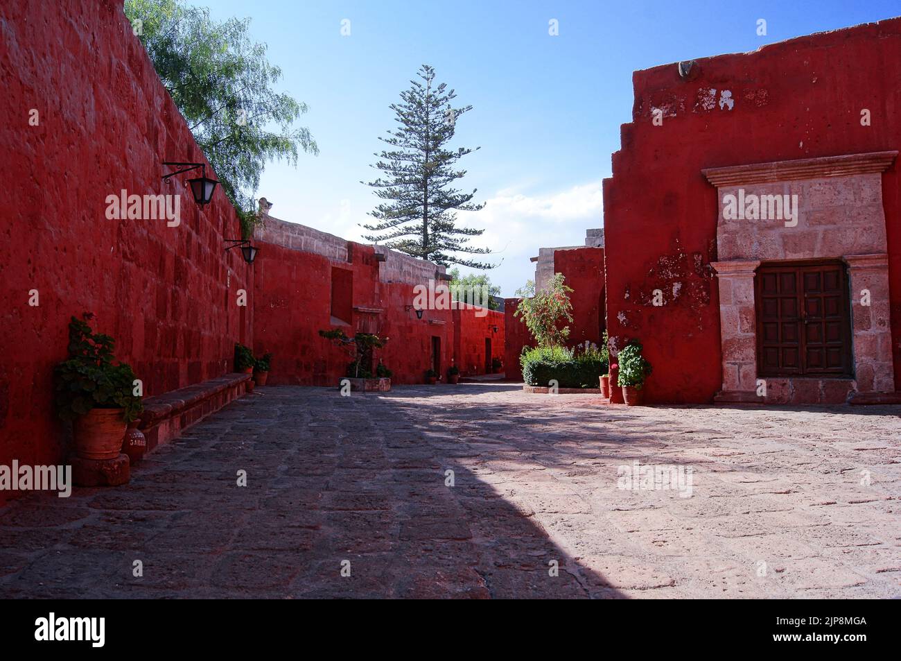 An old beautiful one-floor building painted in red with a front yard ...
