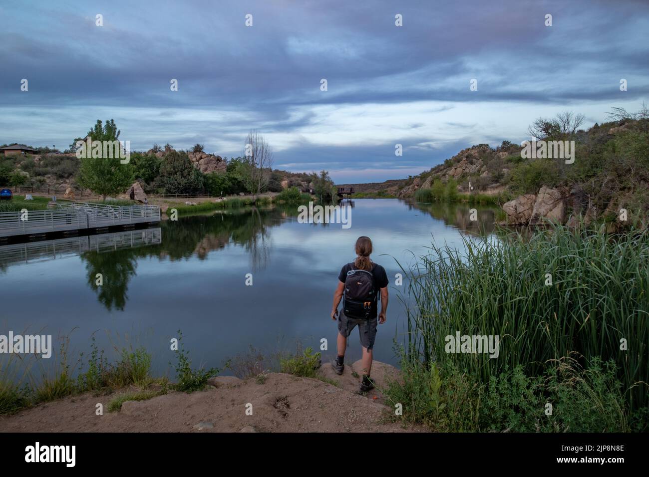 A Caucasian male hiker admiring the view of Fain Lake after sunset in ...