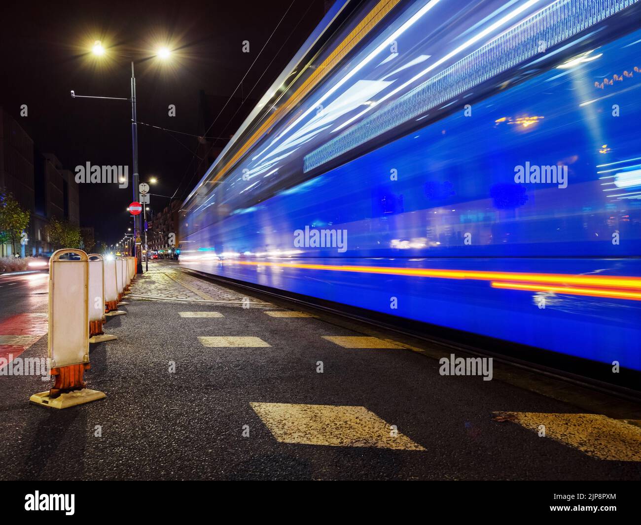 city tram departure from tram station in the night city. urban public ...