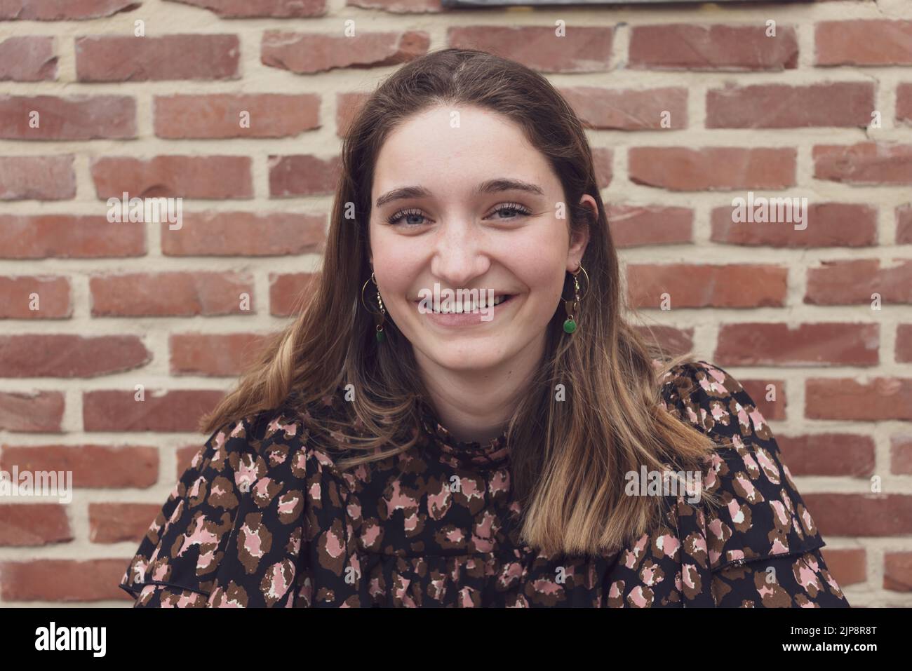 Close Up Shot of a Beautiful brown Haired Teenager smiling, against a ...