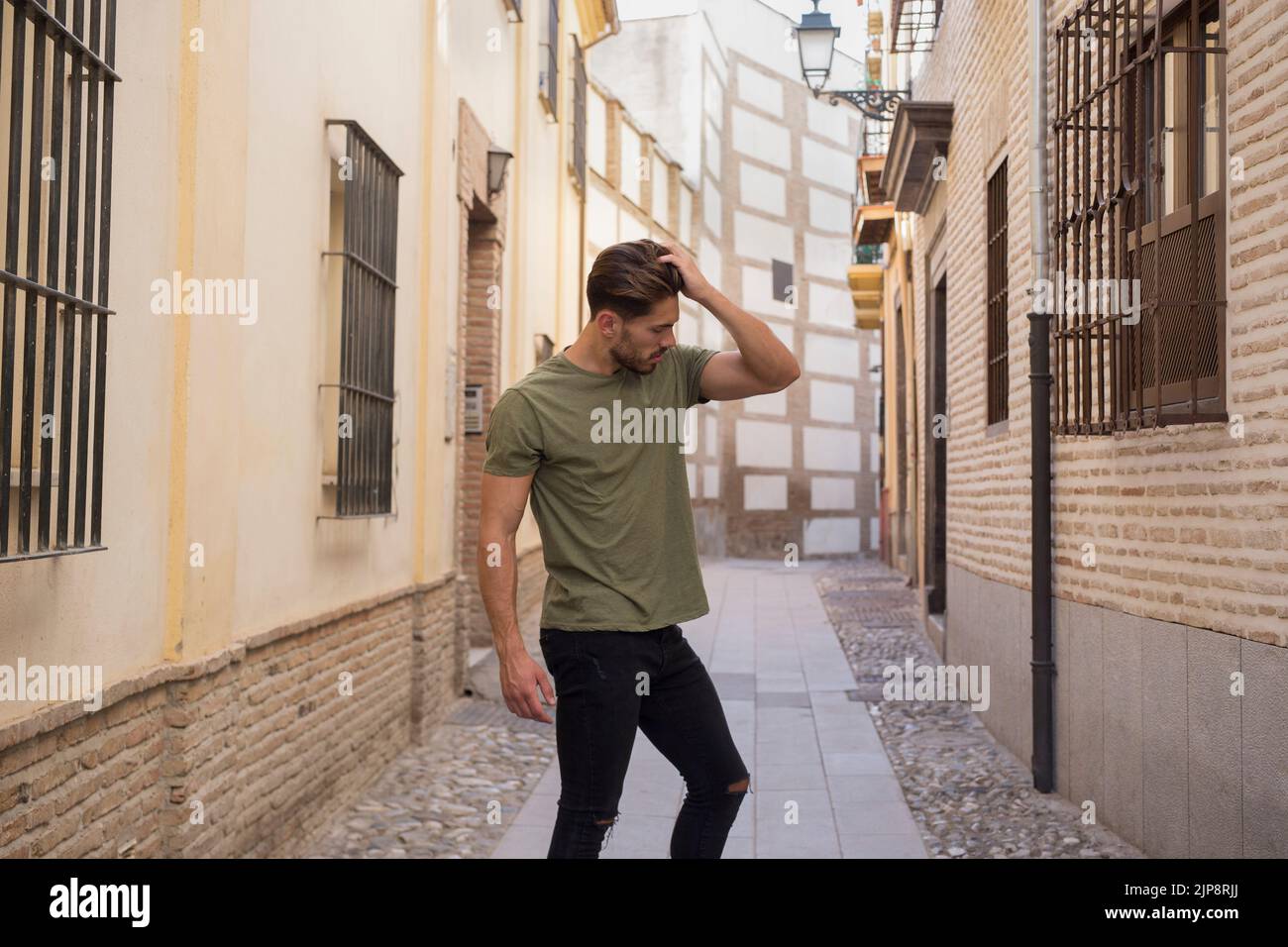 Side view of metrosexual male with muscular body in t shirt and jeans ...