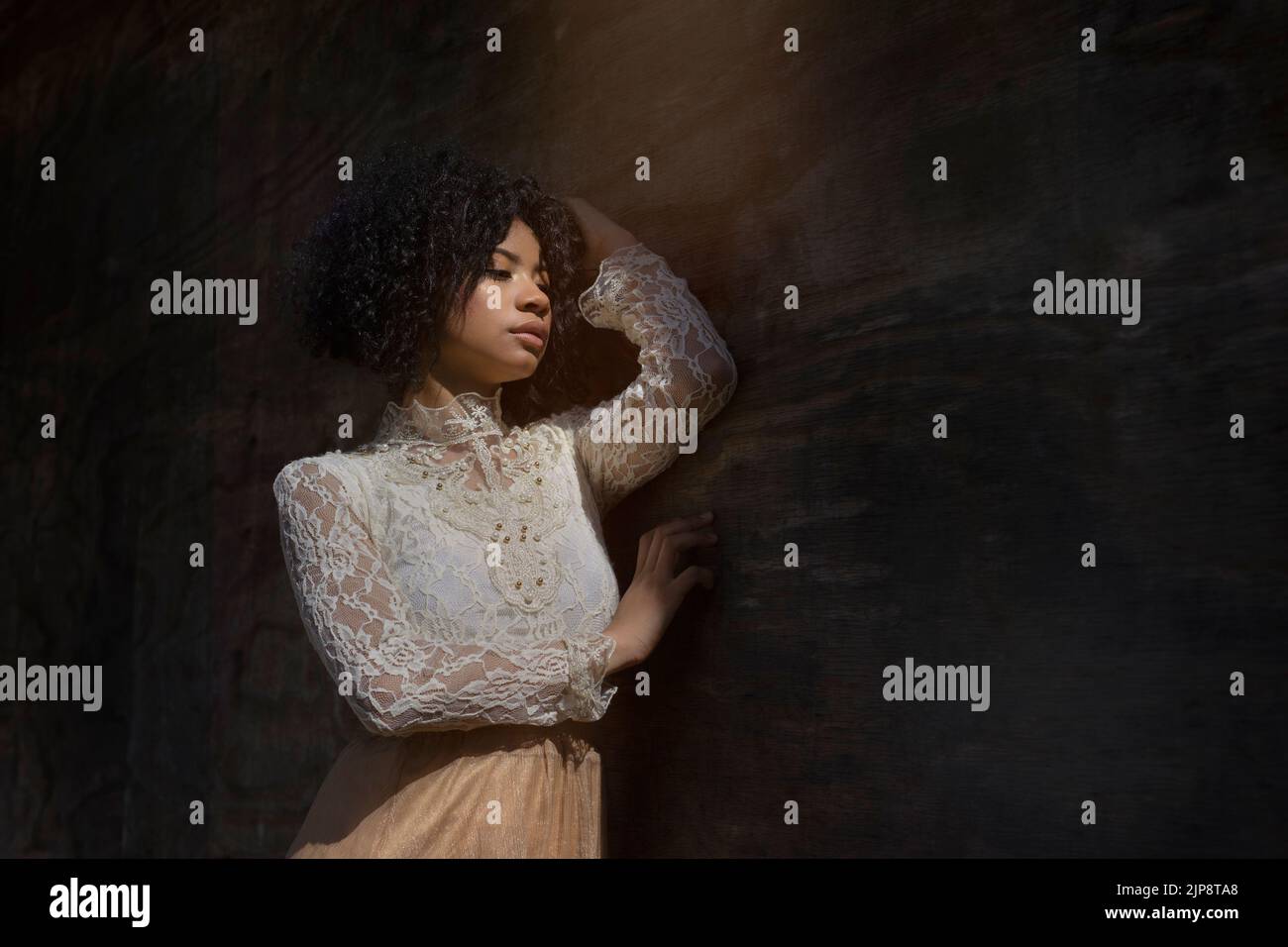 Thoughtful Young African American Female Model With Dark Curly Hair In Romantic Dress Leaning On