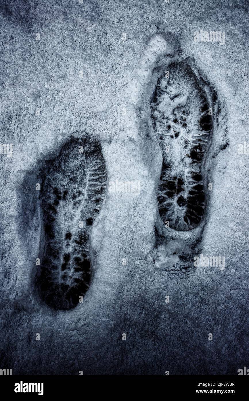 A vertical top view of footsteps on the ground covered with snow Stock ...