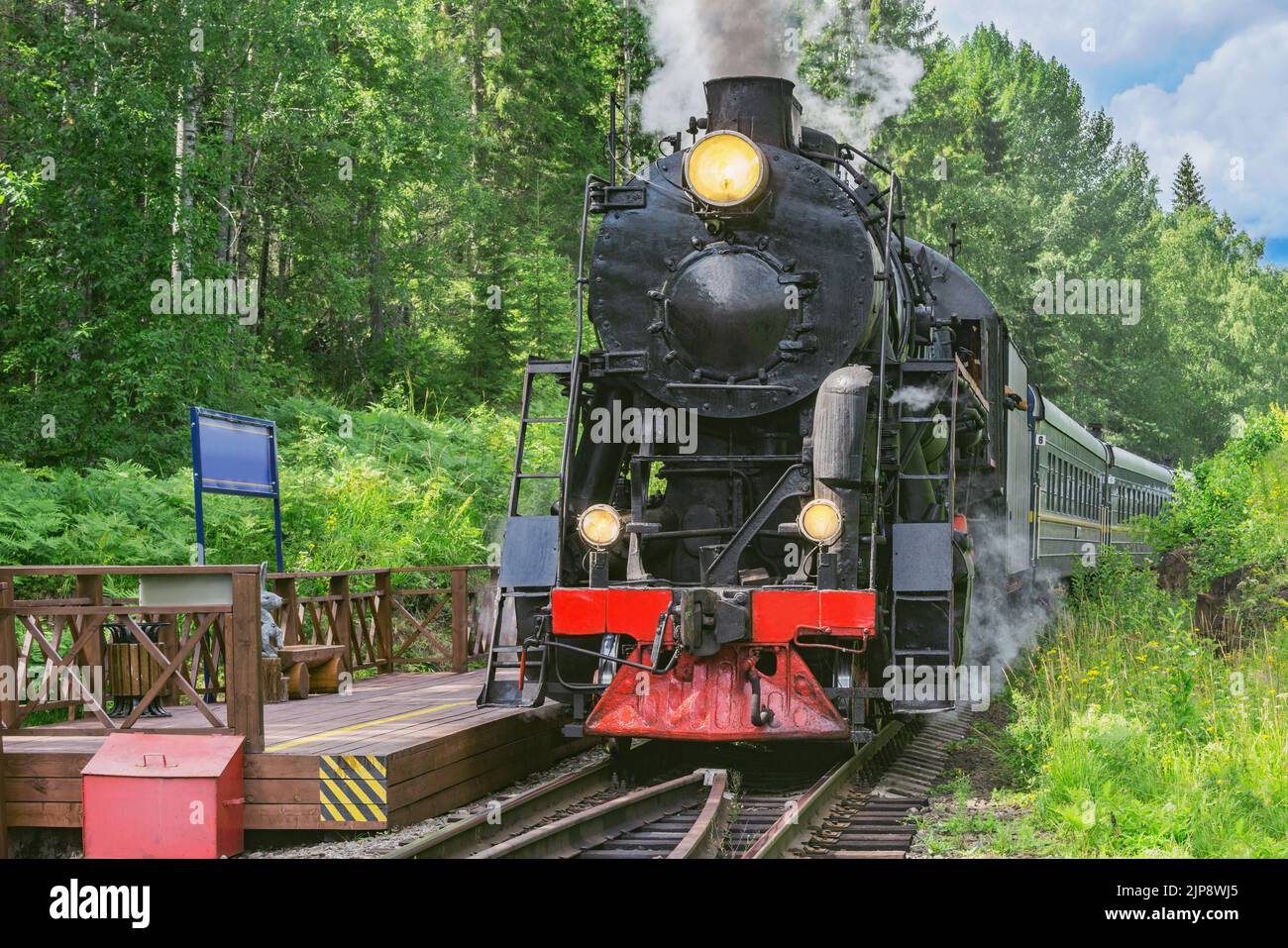 Retro steam train approaches to the station Stock Photo - Alamy