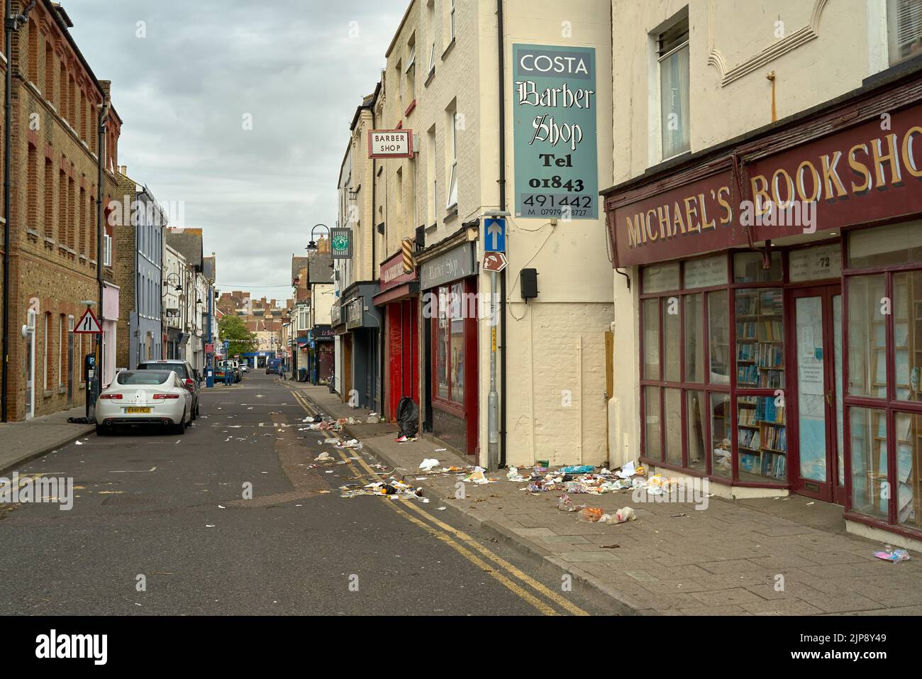 A dirty street in Ramsgate with litter and trash spread on the sidewalk ...