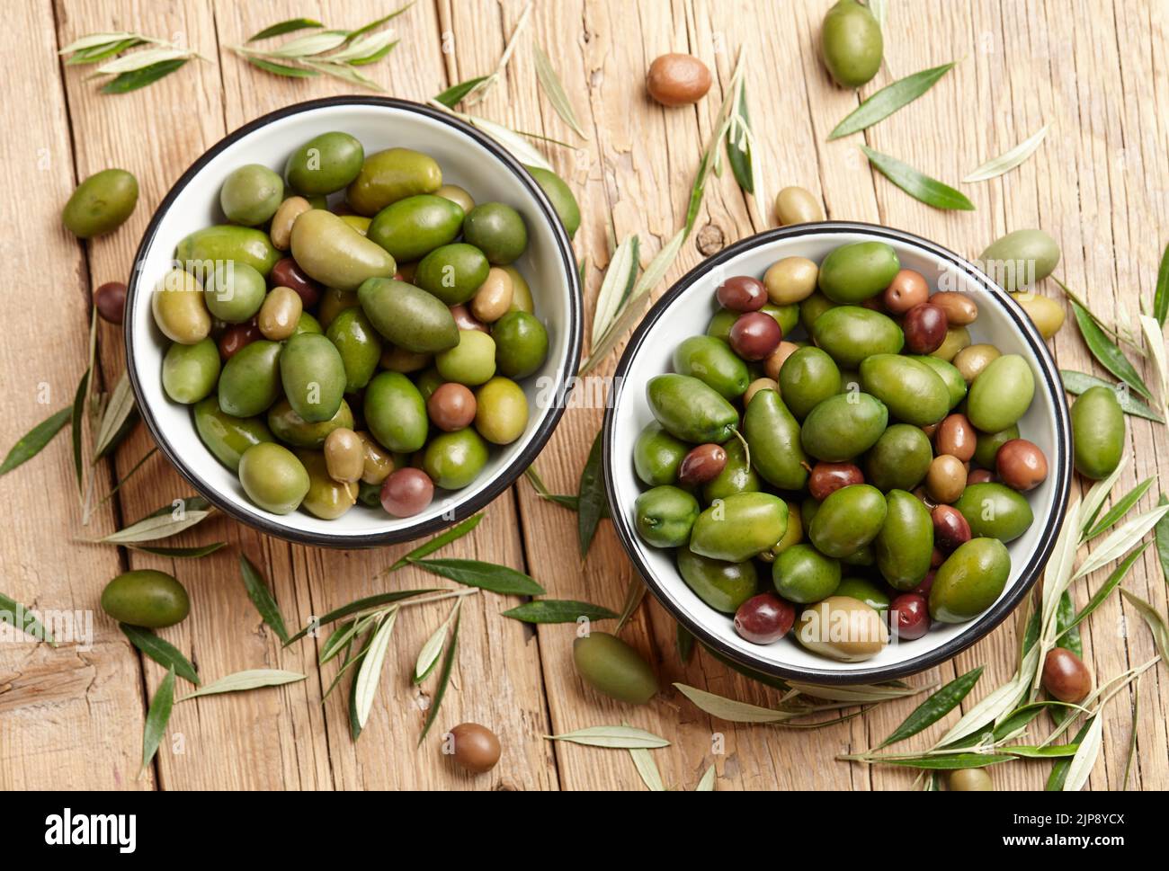 Mixed olives in bowls on wooden planks background Stock Photo - Alamy