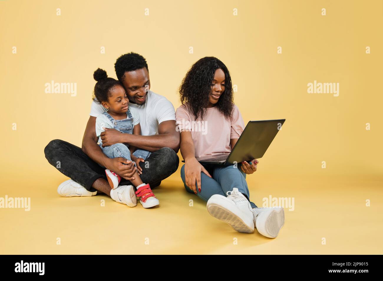 Happy family, technology, communication concept. Young african parents ...