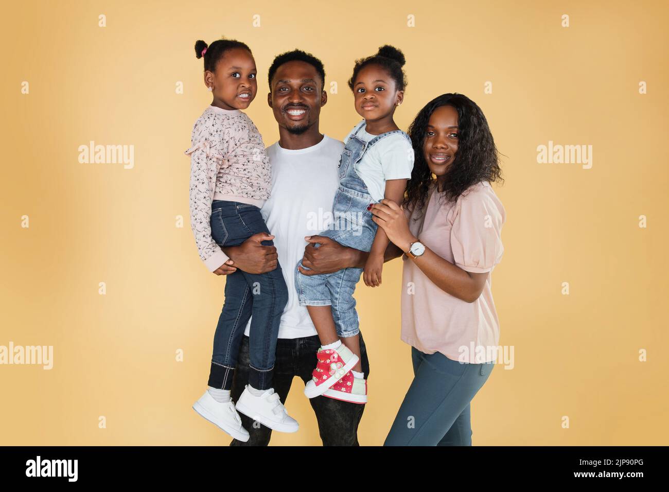 Loving family. Happy african parents and two daughters embracing each ...