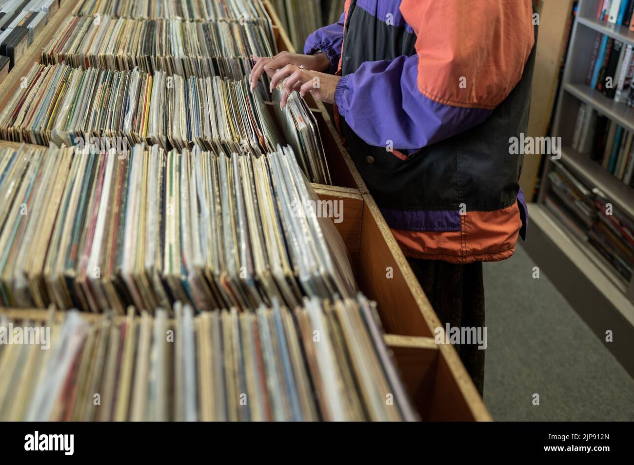 Woman searching for music at local store Stock Photo - Alamy