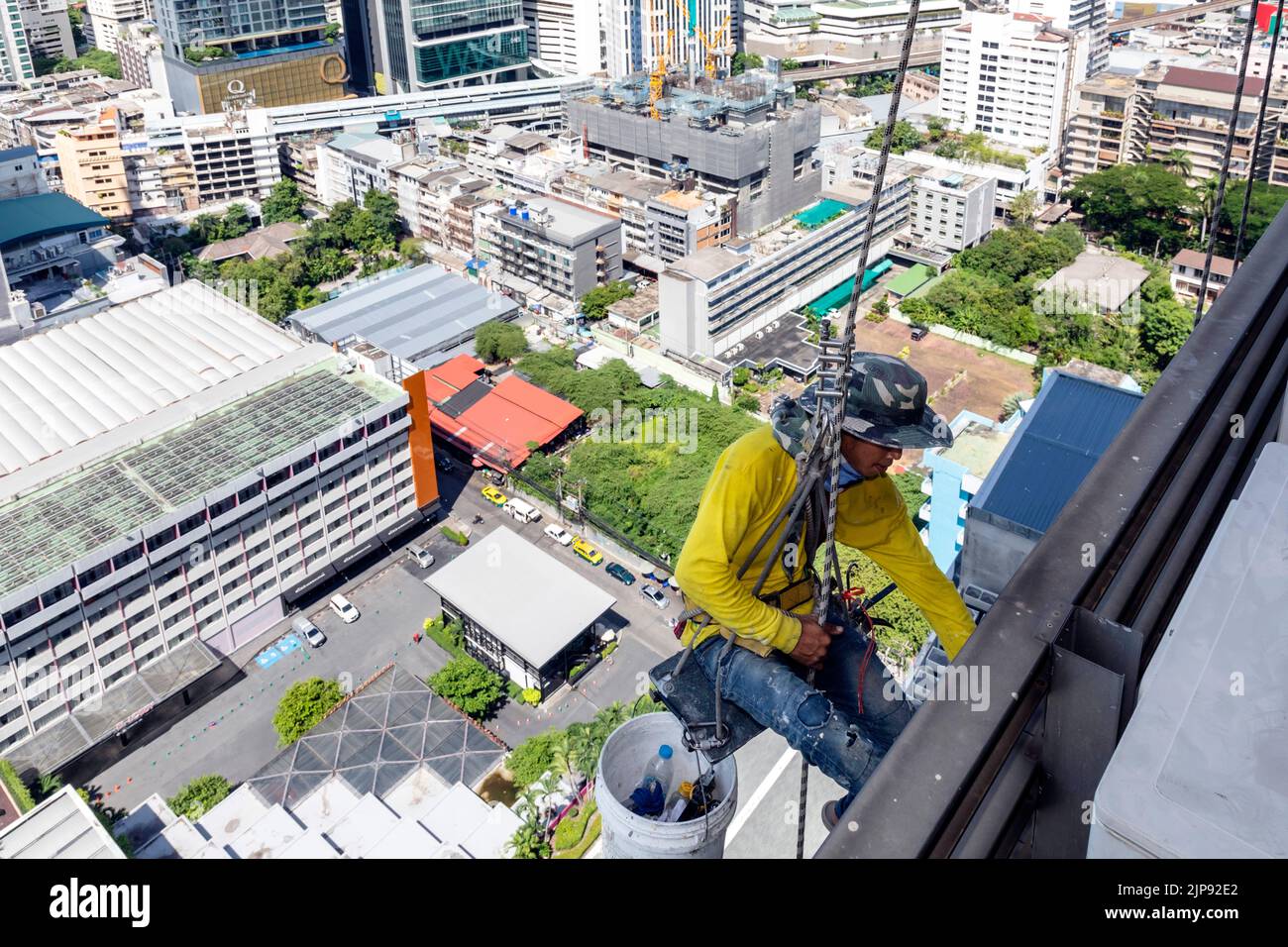 Thai worker using Bosun Chair to repair skyscraper, abseiling above ...