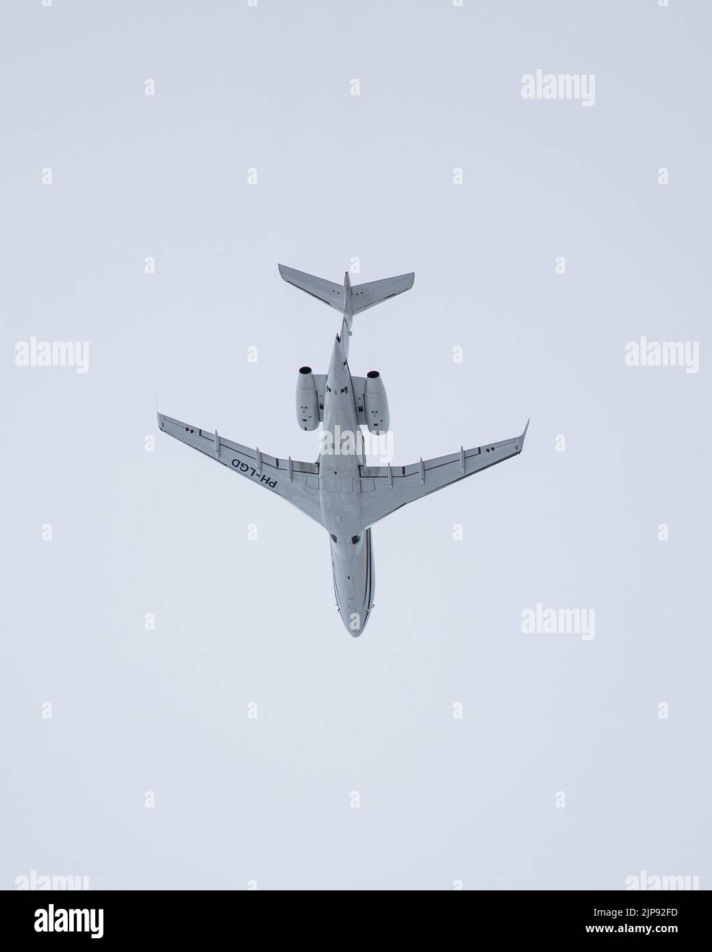 A vertical shot of an airplane taking off with an overcast sky in the ...