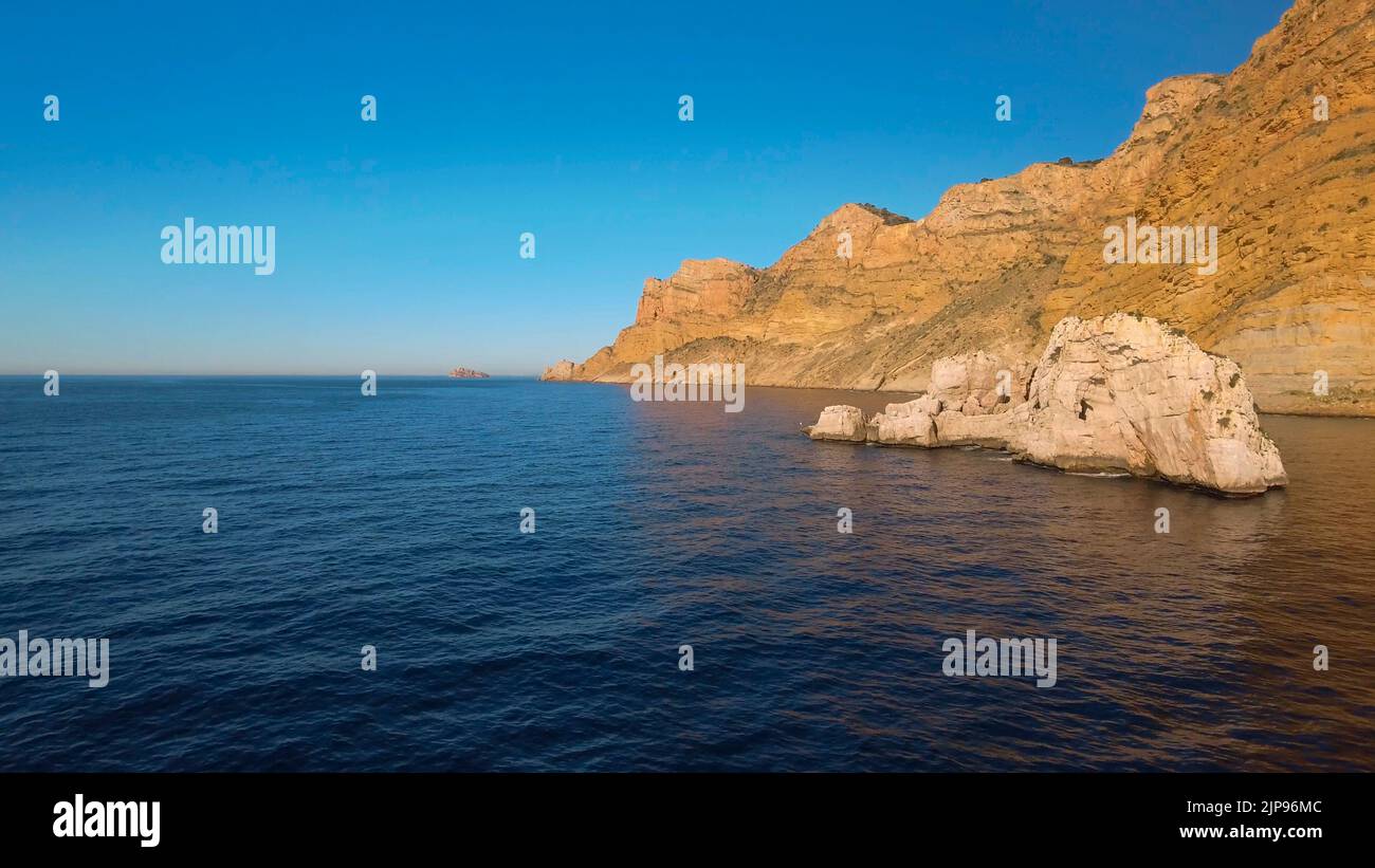 Sierra Helada cliffs and Mitjana island from the sea, aerial view ...