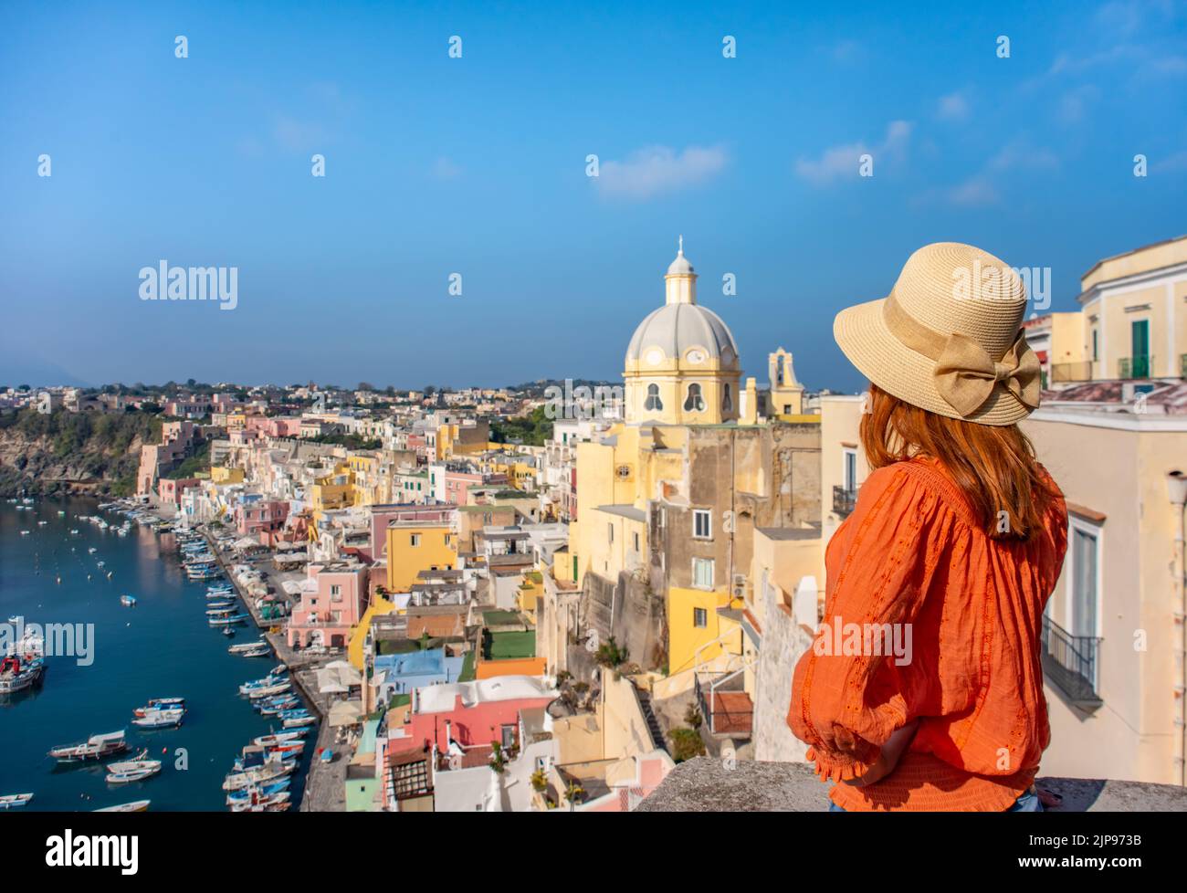 Beautiful young girl over panoramic view of Procida Island, Naples ...