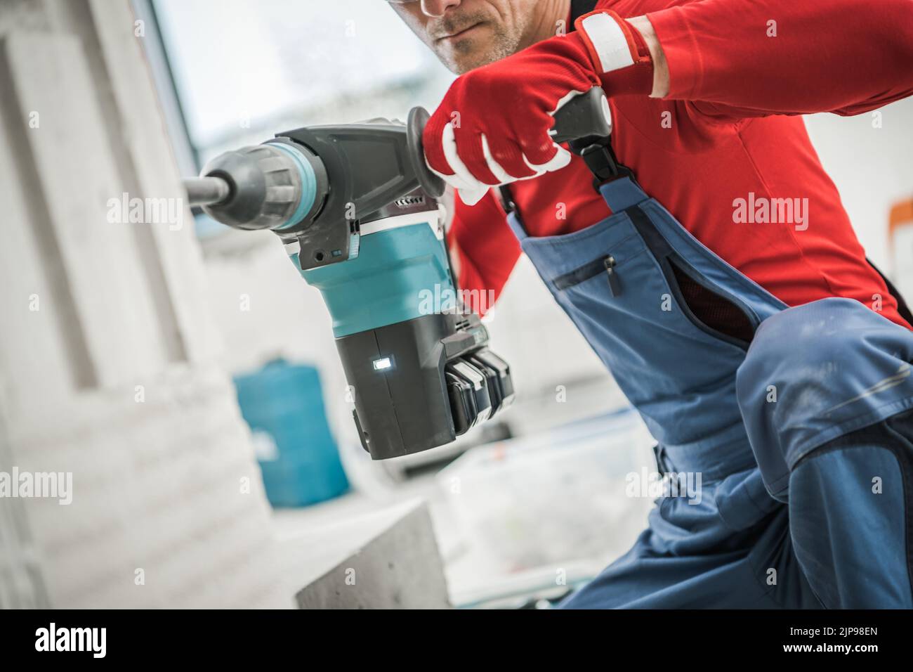 Caucasian Worker Drilling the Hole in the Wall of Newly Built ...