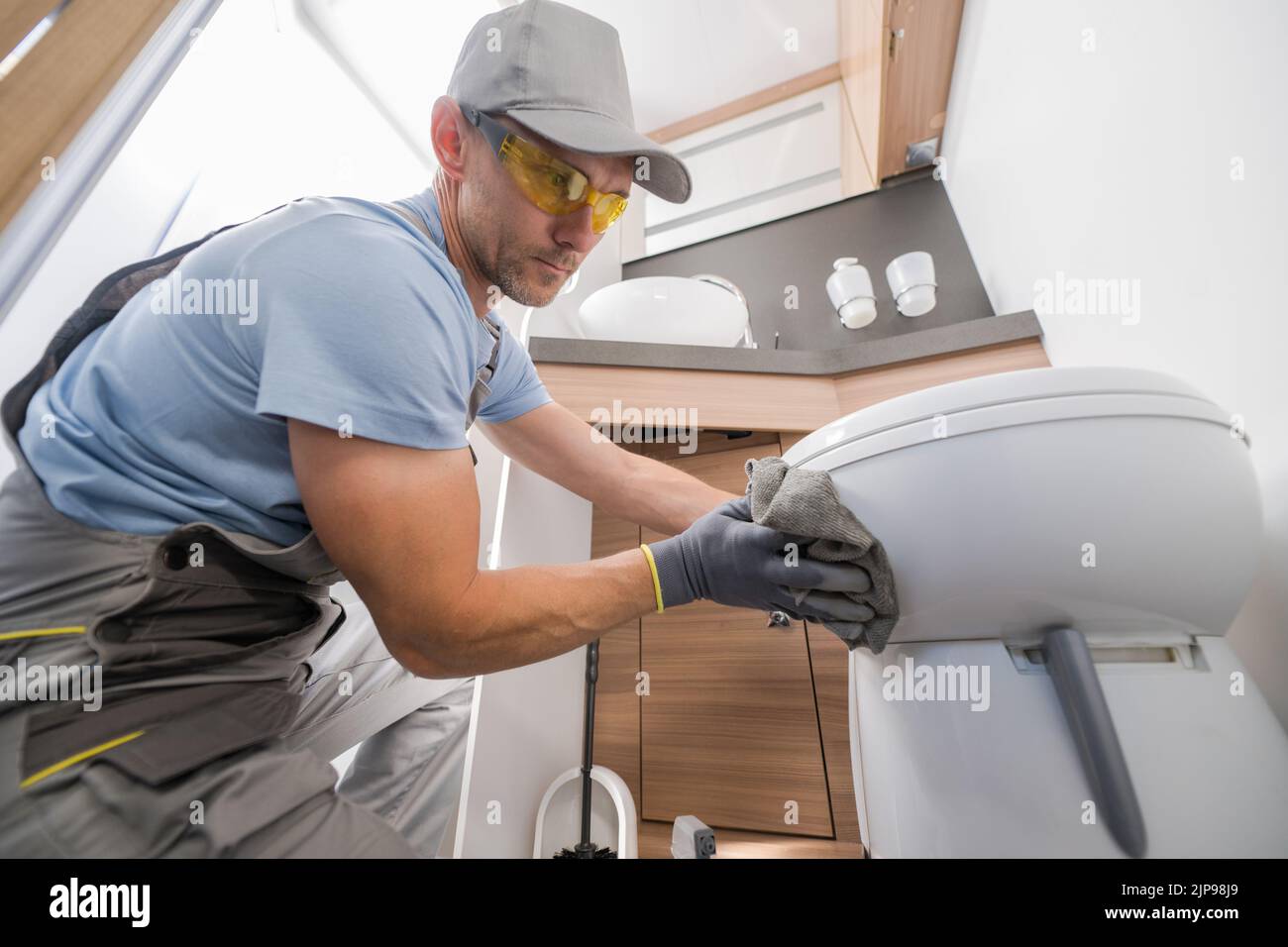 Caucasian Man Washing the Toilet Surface in the RV Bathroom with a ...