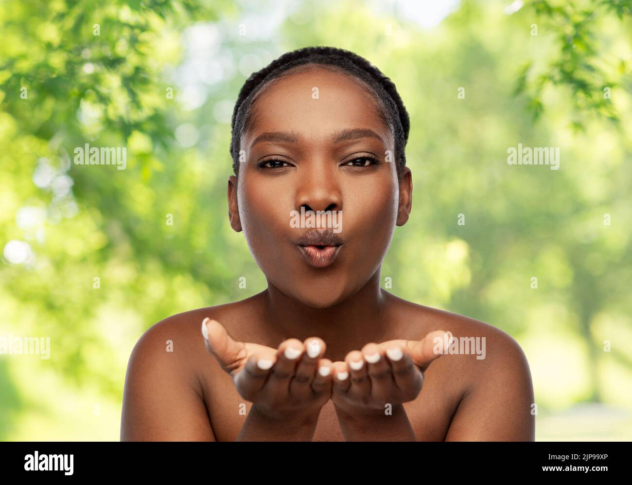 african woman blowing something off her hands Stock Photo - Alamy