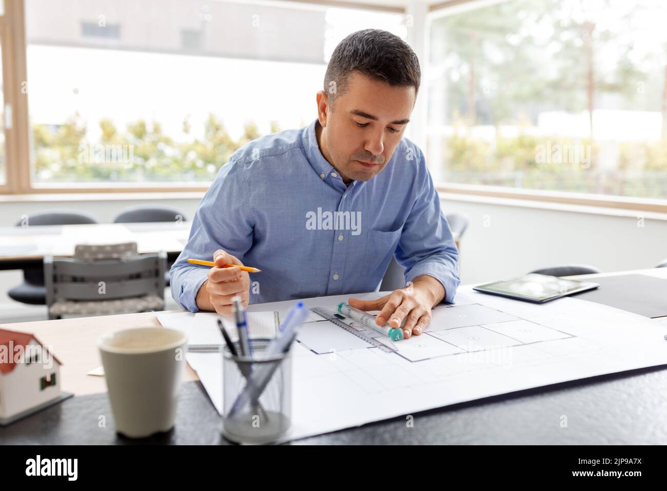 architect with blueprint working at home office Stock Photo - Alamy