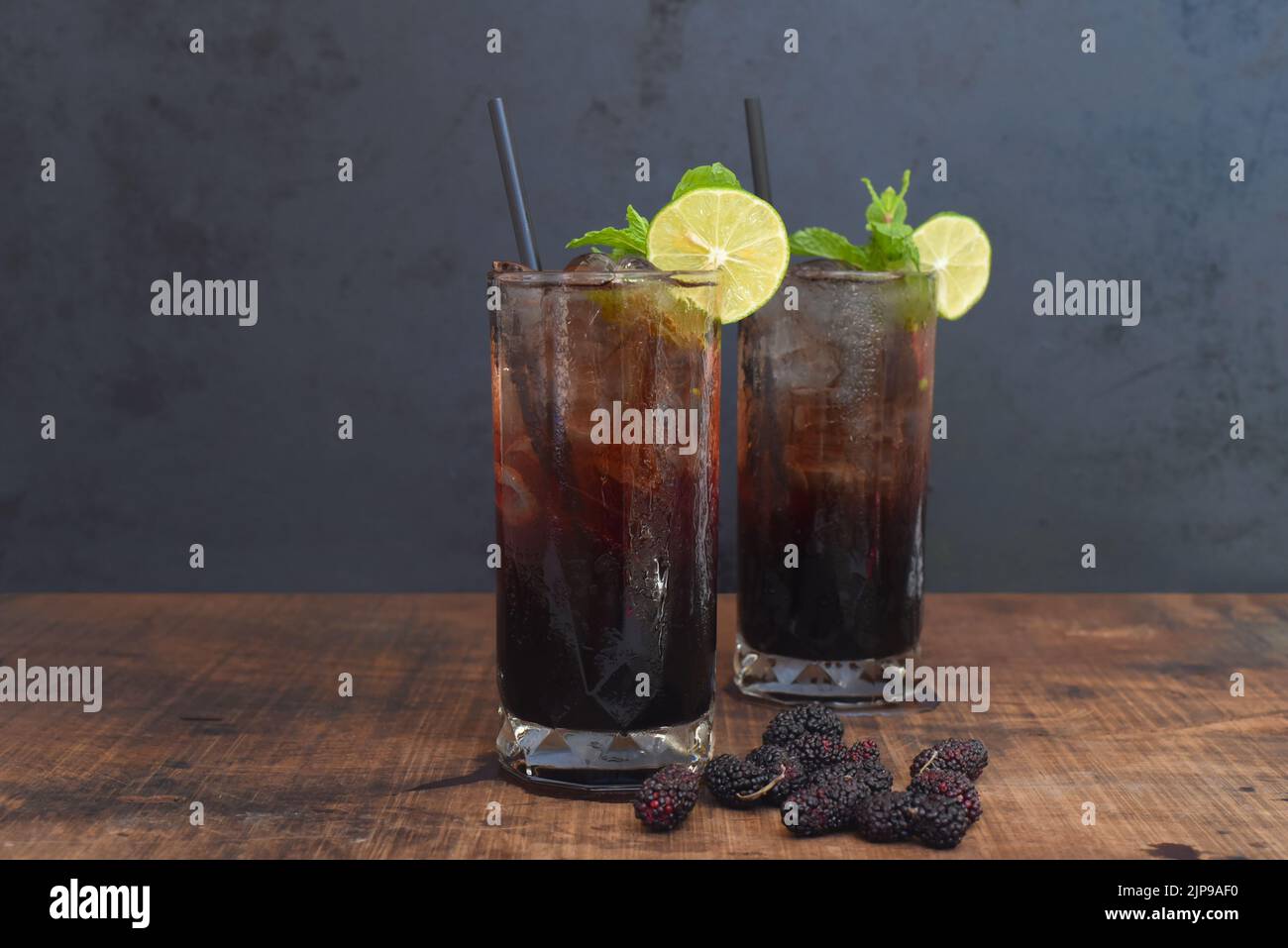 Two highball mulberry wine cocktails on wooden table and black ...
