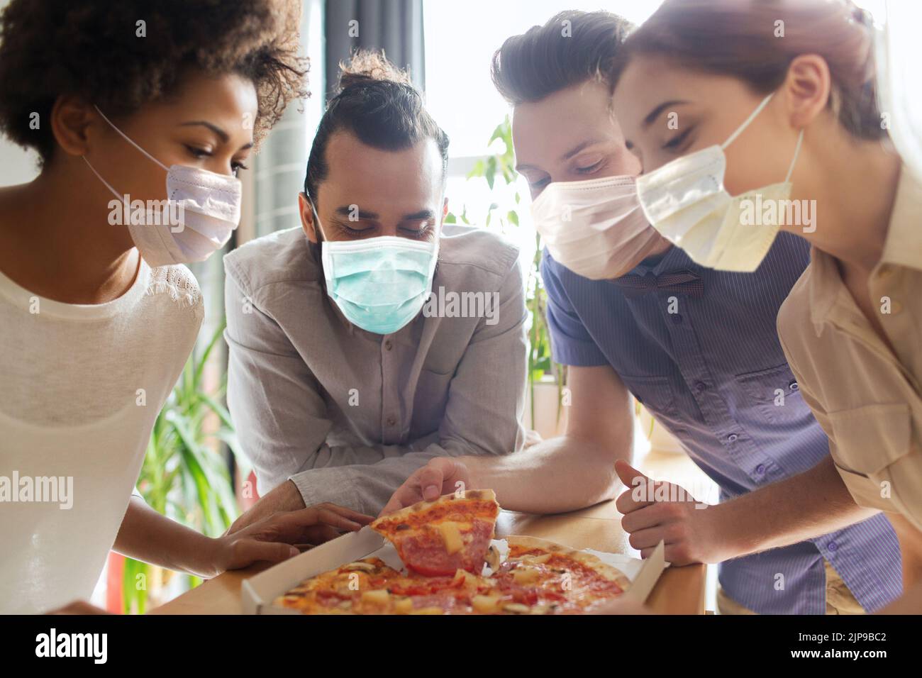 business team eating in masks pizza at office Stock Photo - Alamy