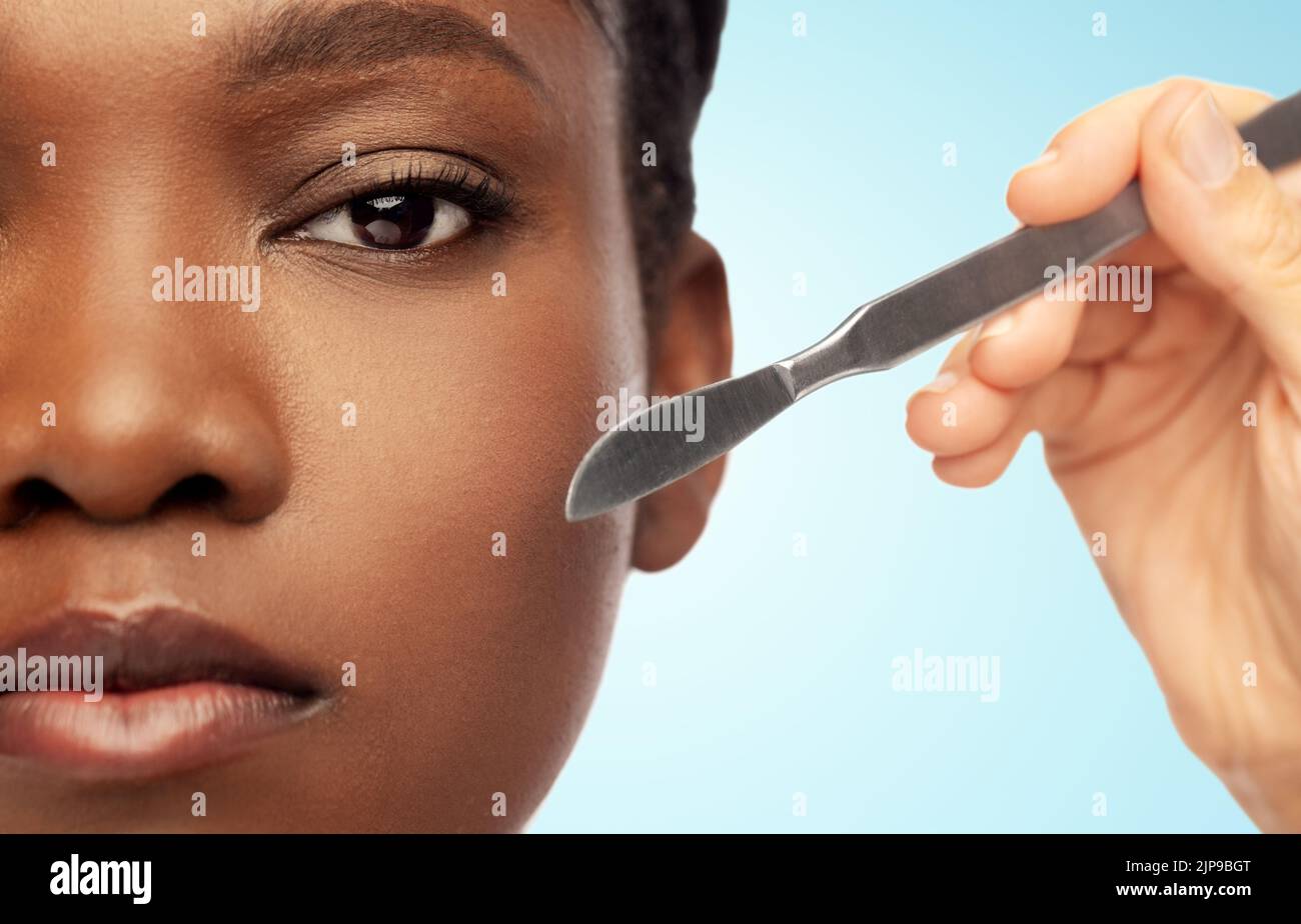 face of african american woman and scalpel knife Stock Photo - Alamy