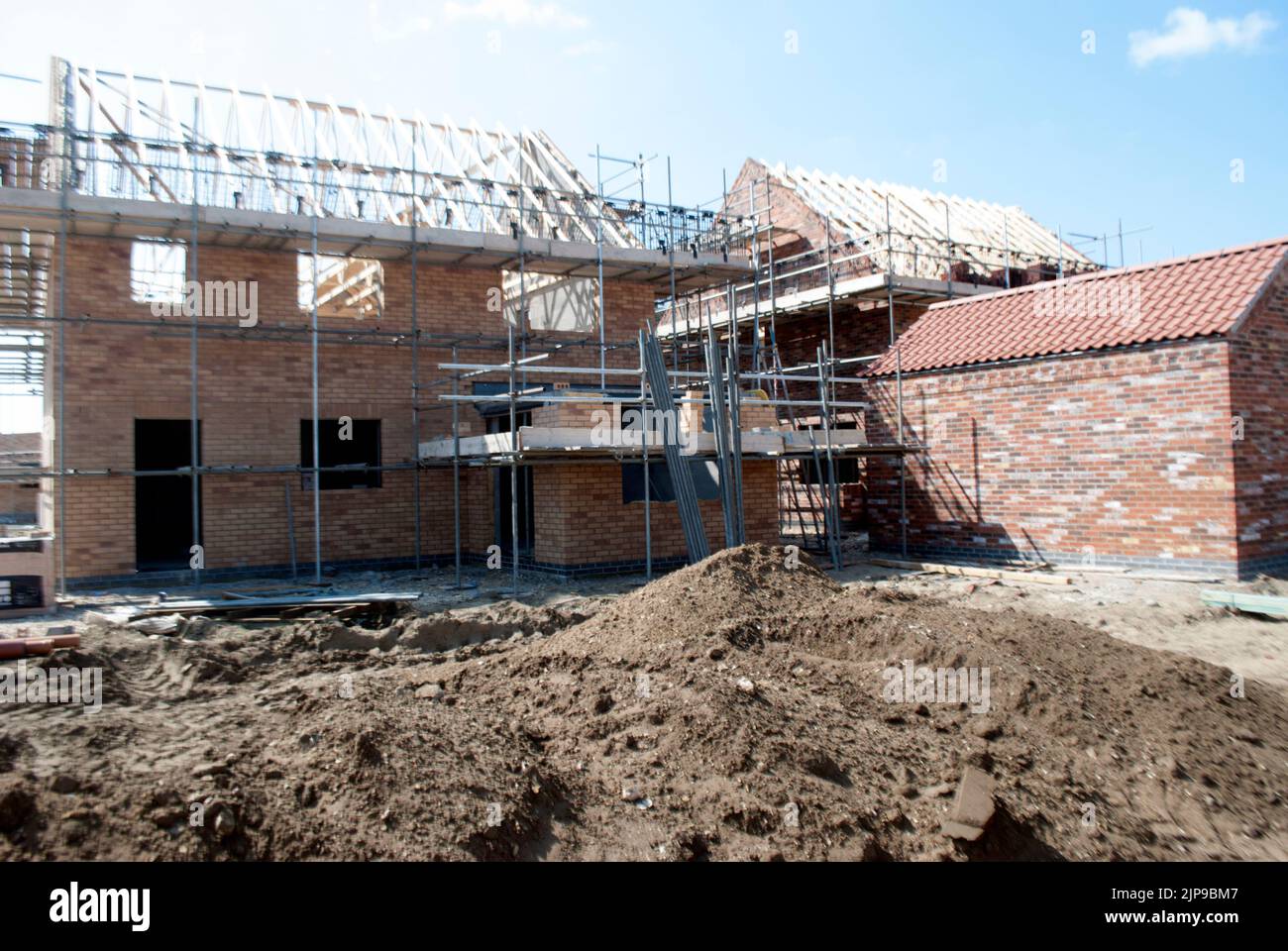 Partially constructed house surrounded by scaffolding on building site ...