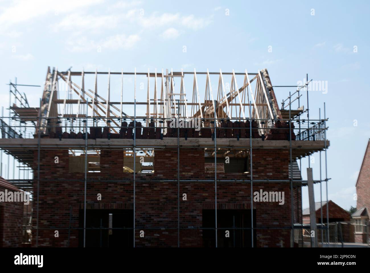 Roof of partially constructed house surrounded by scaffolding on ...