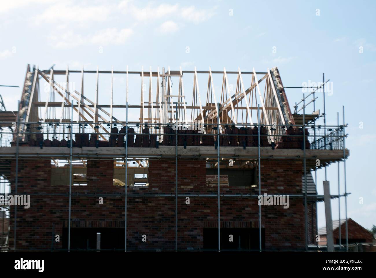 Roof of partially constructed house surrounded by scaffolding on ...
