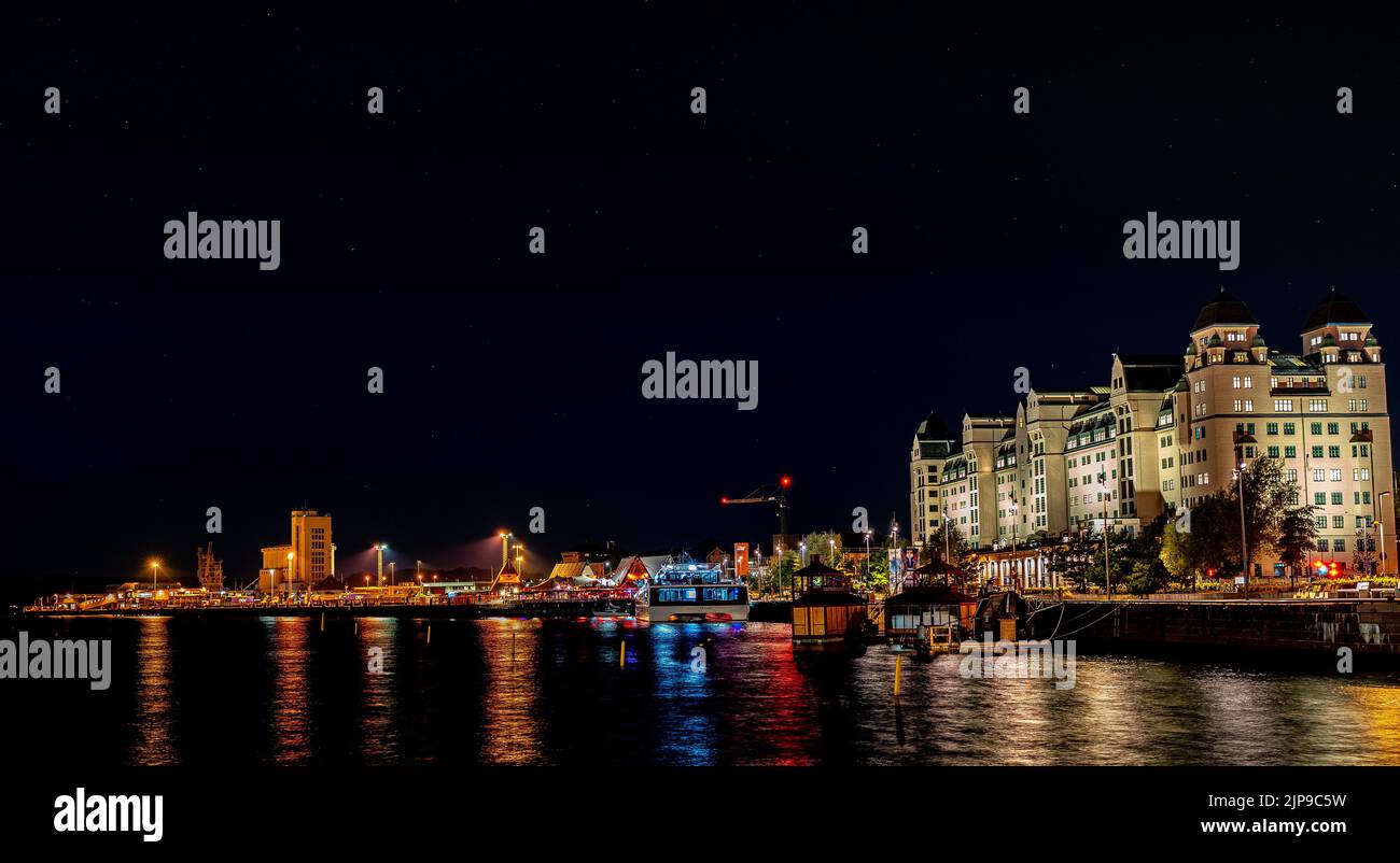 A scenic shot of colorful city lights reflecting on water during ...