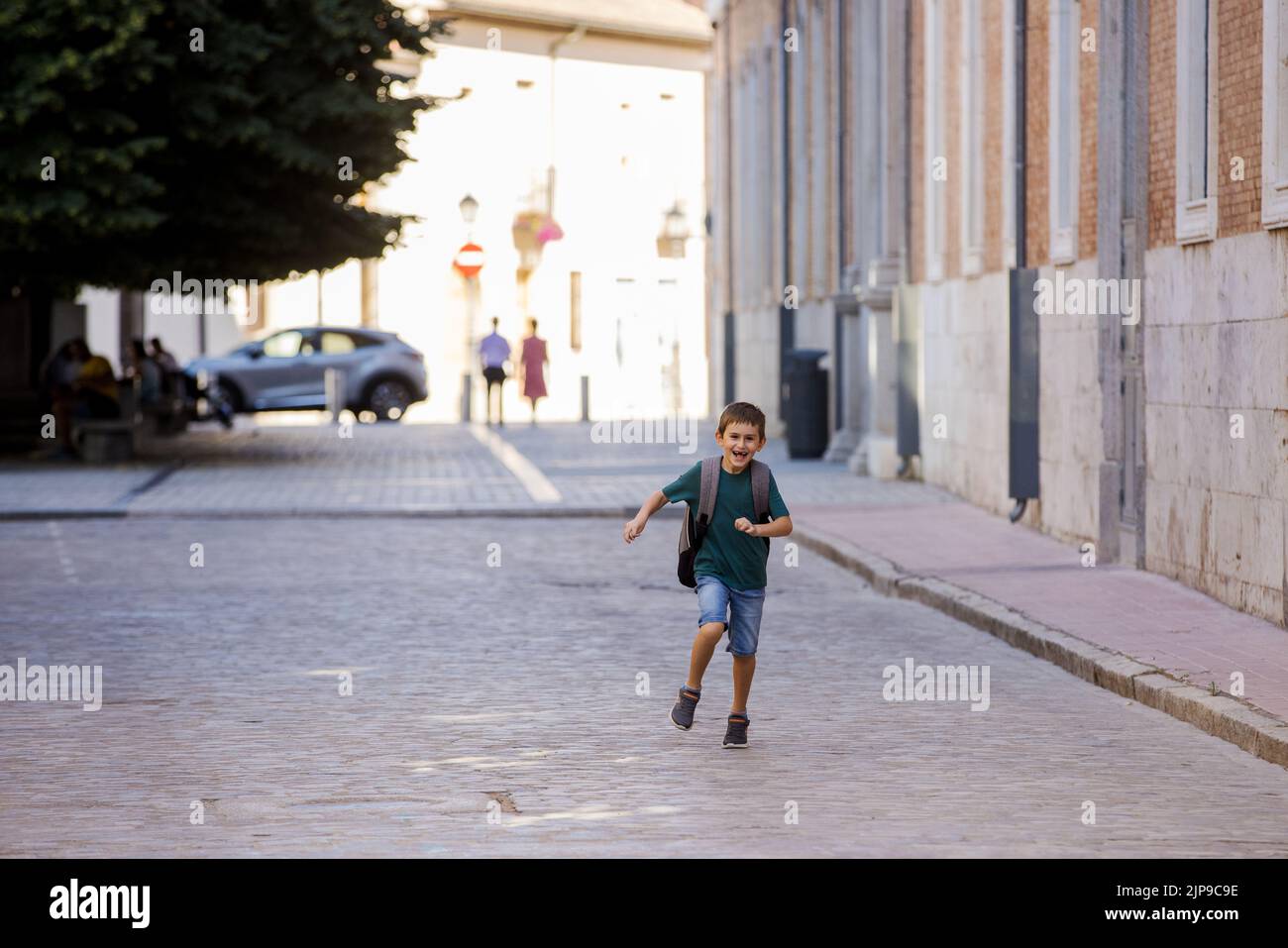 The happy boy running to his parents with a backpack after school Stock ...