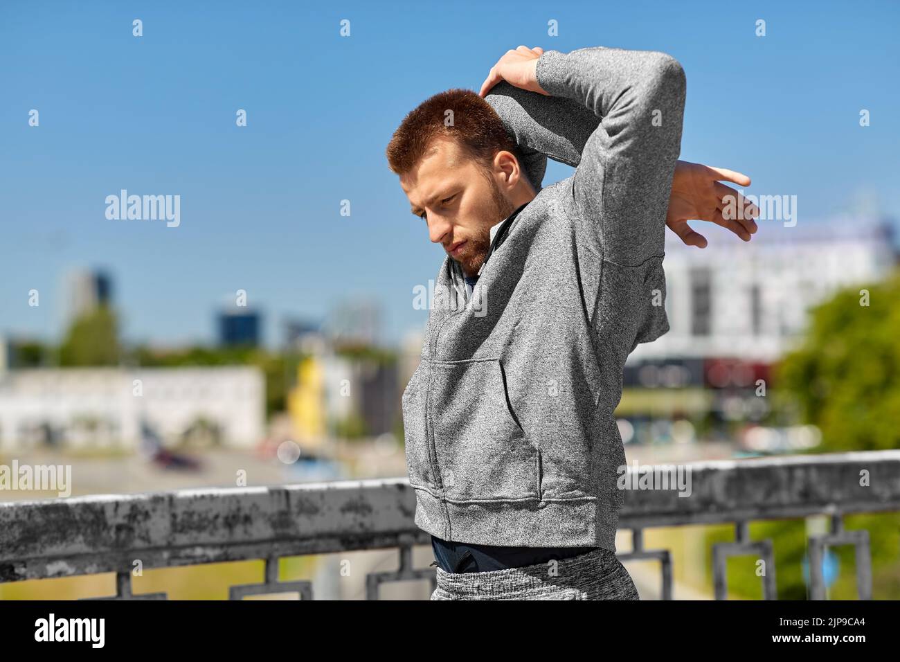 man stretching hand and shoulder on bridge Stock Photo - Alamy